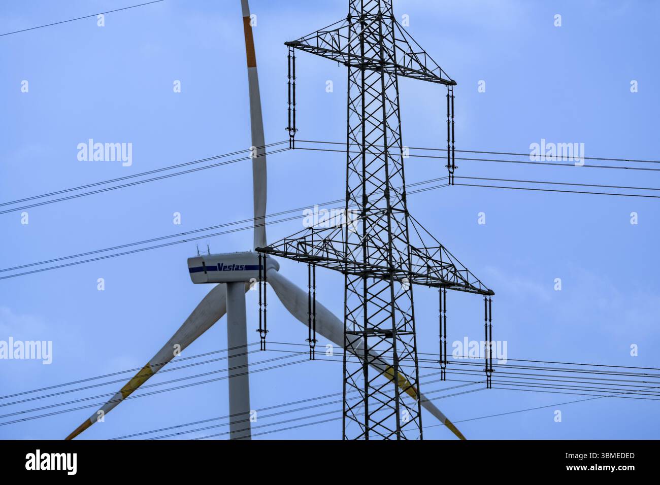 Power pylon with high-voltage lines and Vestas wind turbine at the ...