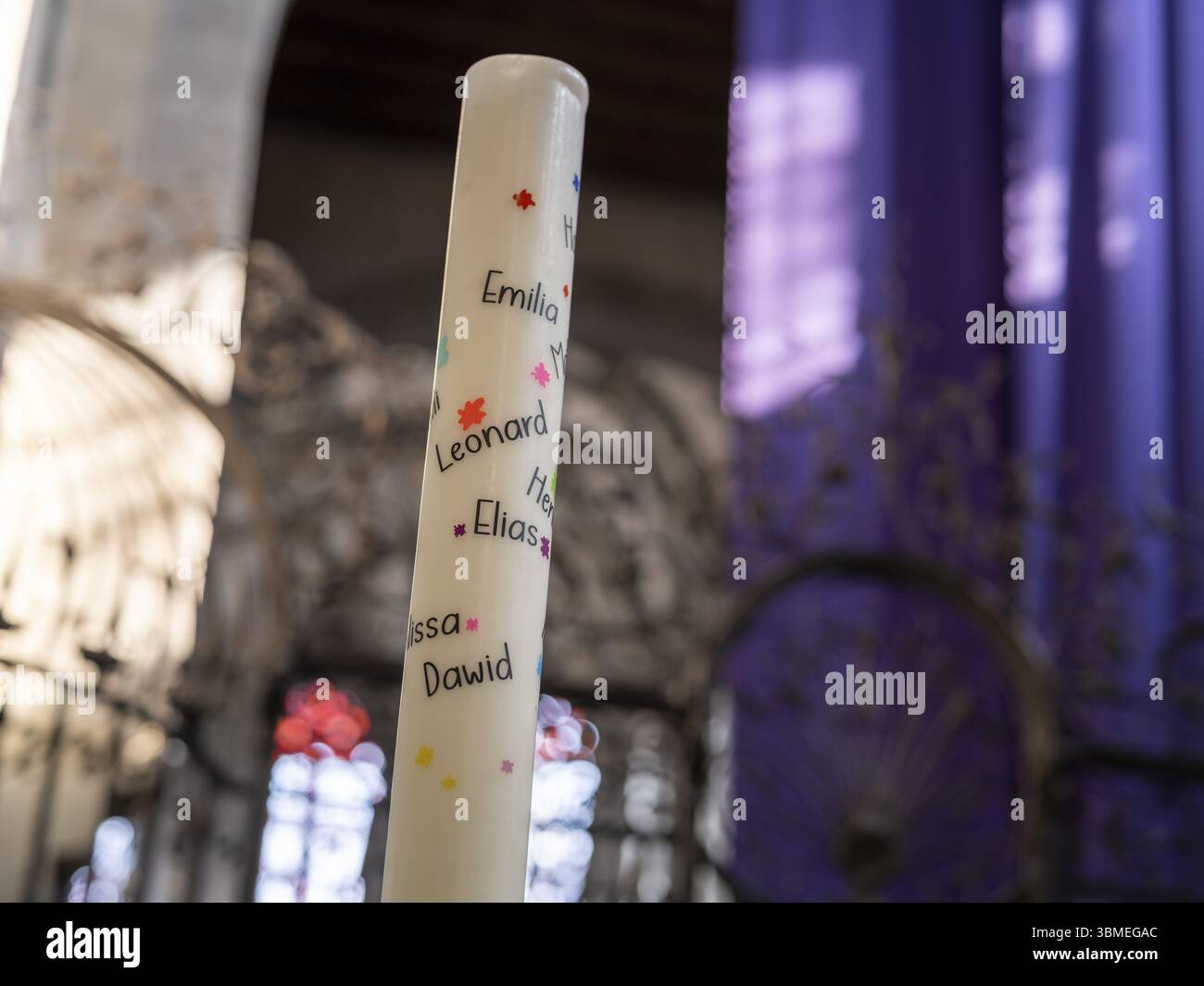 Candle with the names of the First Communion children in the chancel of ...