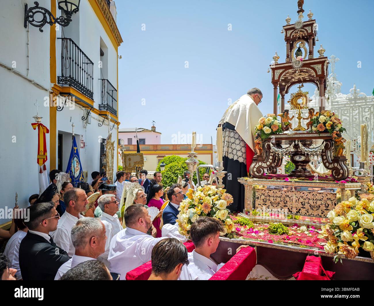 Carrión, Spain, June 19 2025, The priest ascends the float to retrieve ...