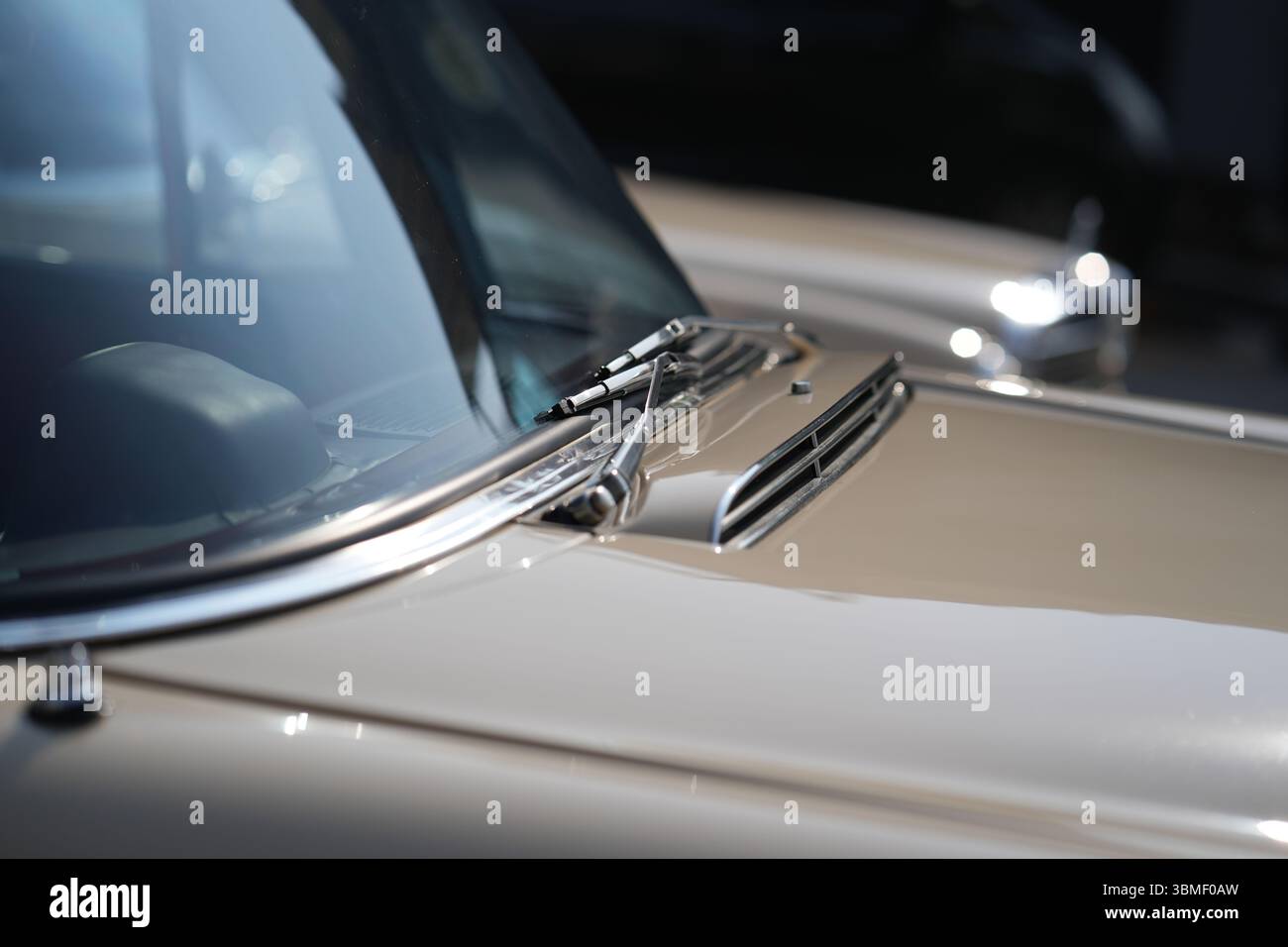 The windshield and chrome wipers of a classic car showcase the timeless ...