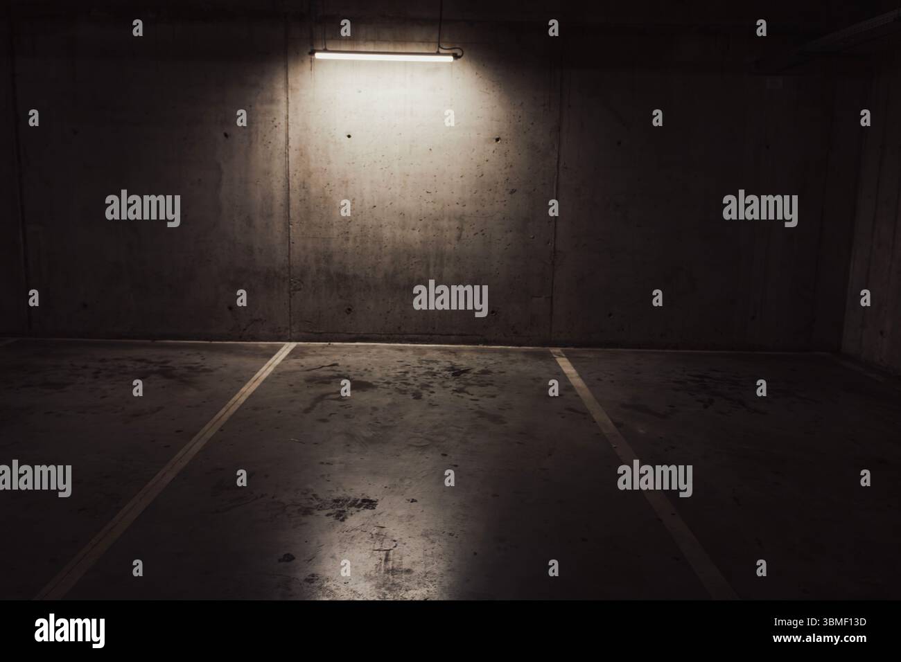 Empty underground garage. Empty parking lot with overhead dim light ...