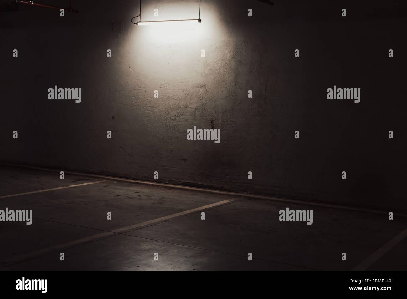 Empty underground garage. Empty parking lot with overhead dim light ...