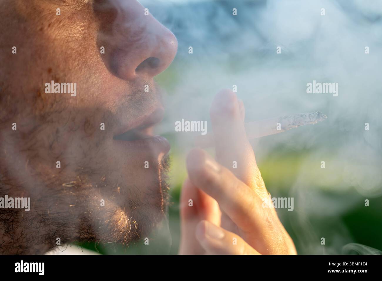 Kammlach, Bavaria, Germany - June 24, 2025: Close-up of a man smoking a ...