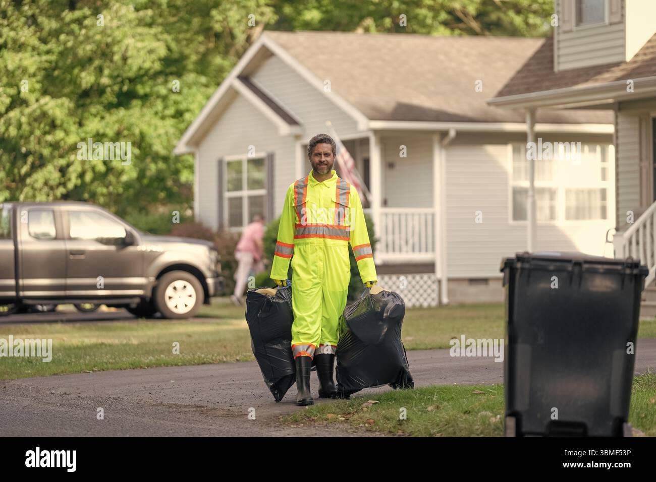 Pollution and recycling. Man putting garbage bag in a trash bin ...