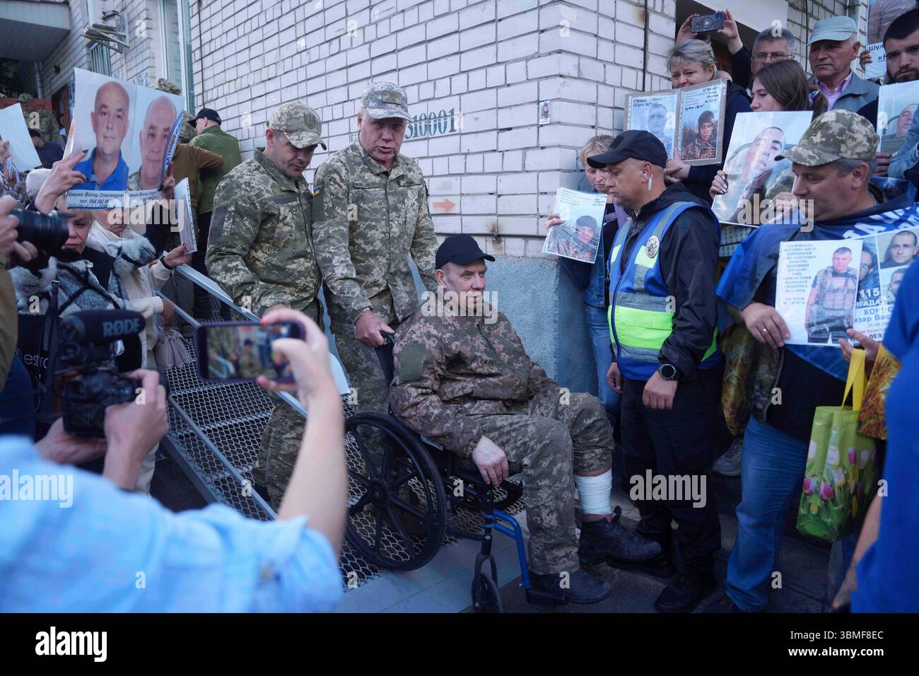 A Ukrainian serviceman uses a wheelchair to move his comrade from an ...