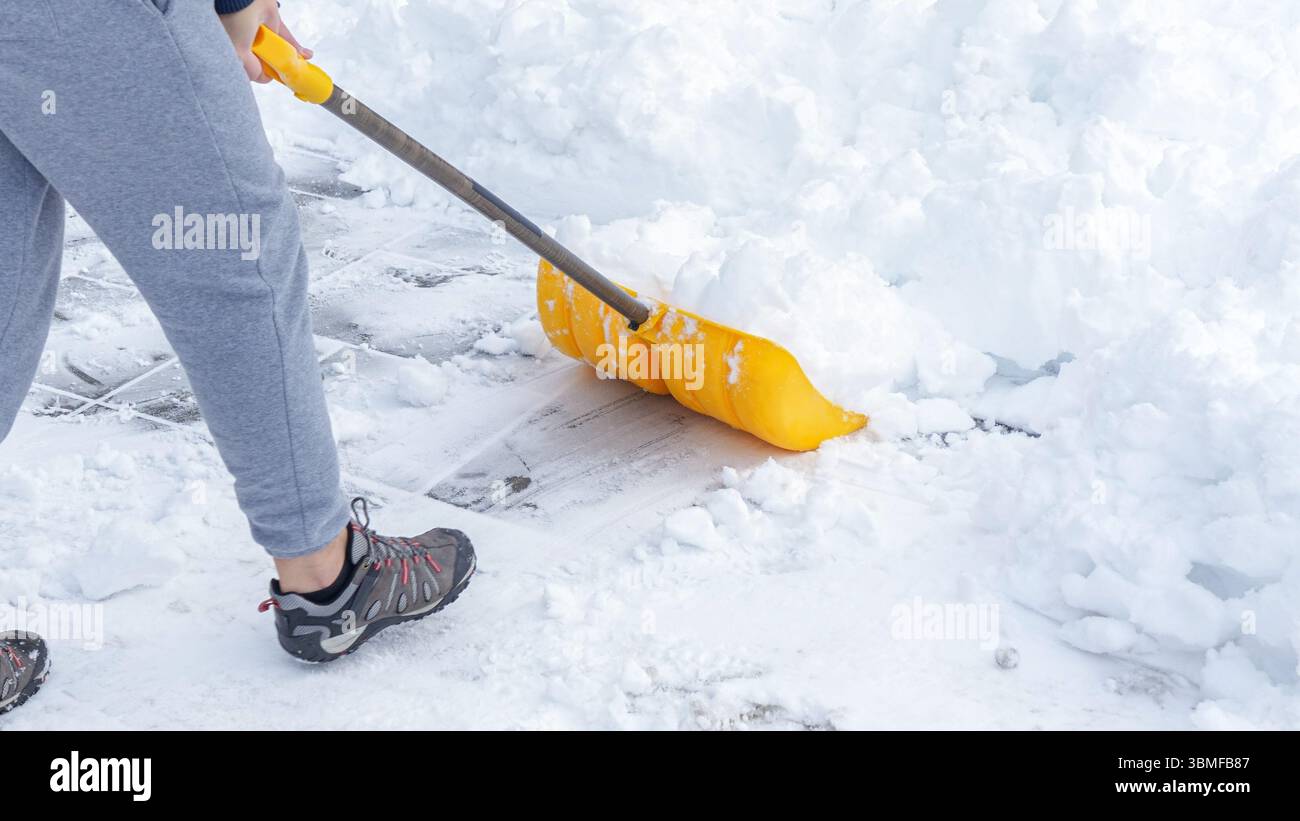 Man shoveling snow off of his driveway after a winter storm in Canada ...