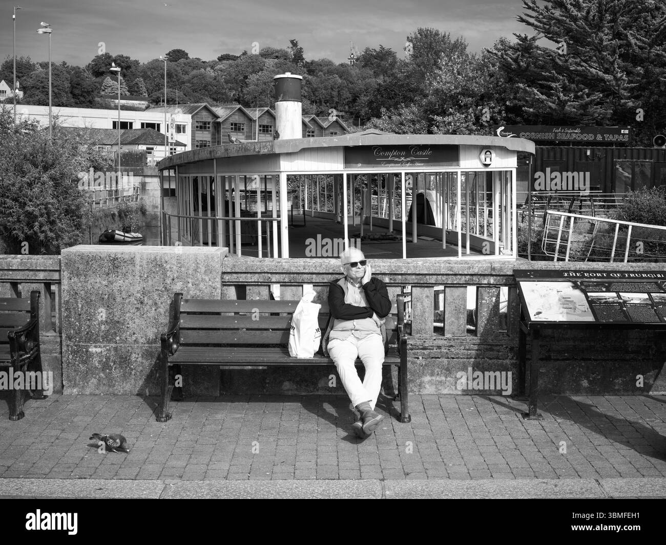 Man sat on bench in front of Paddle Boat Plaza Quay Truro City Cornwall ...