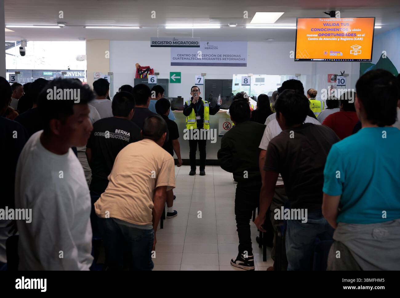 A migration officer directs people deported from the United States at a ...