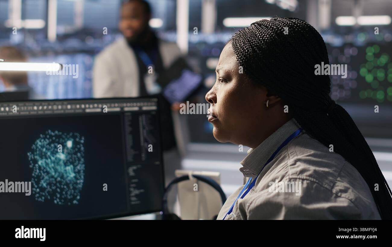 Data center system administrator using PC to monitor neural network AI visualization. African ...