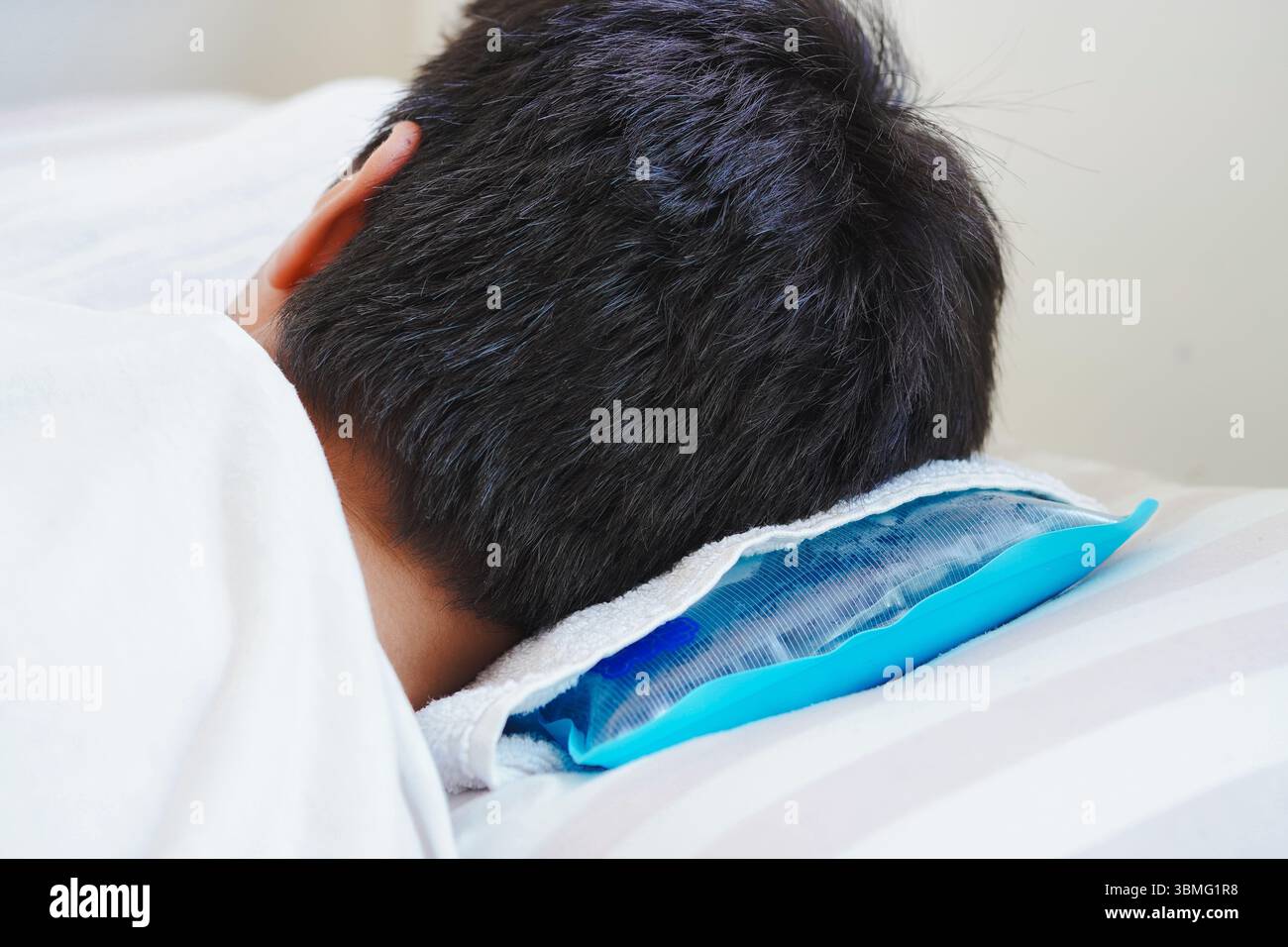 Young man resting in bed with ice pillow due to heat stroke caused by ...