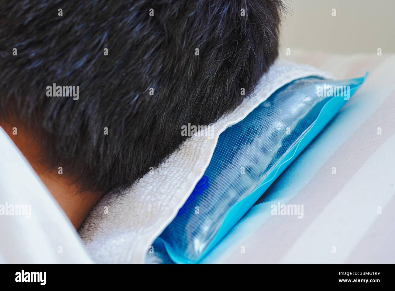 Young man resting in bed with ice pillow due to heat stroke caused by ...