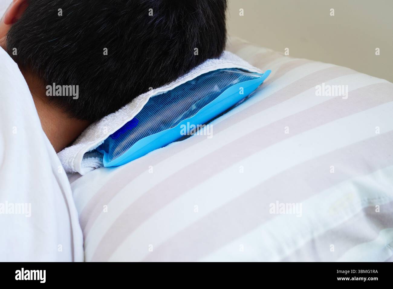 Young man resting in bed with ice pillow due to heat stroke caused by ...