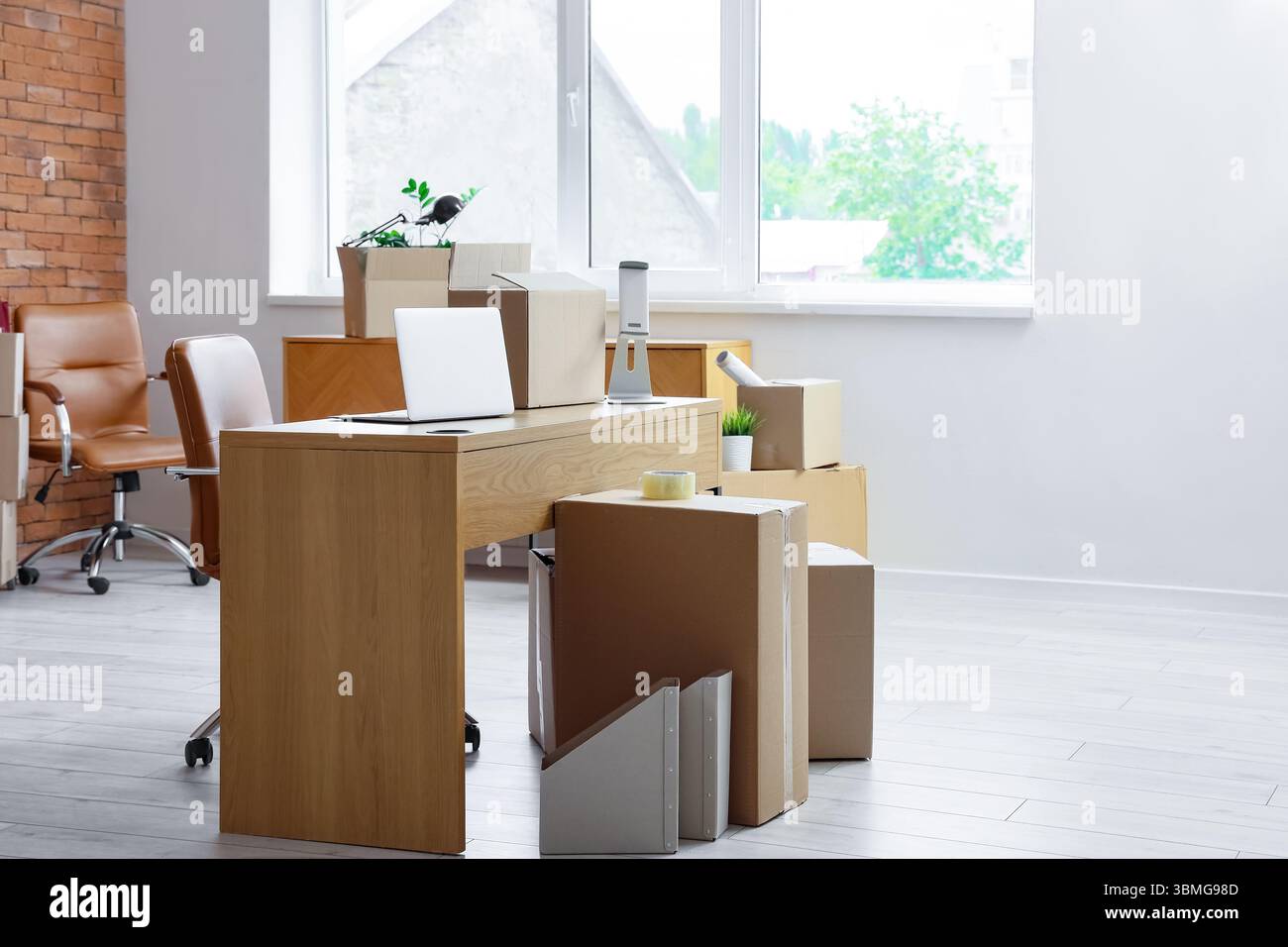 Workplace with laptop and cardboard boxes in office on moving day Stock ...