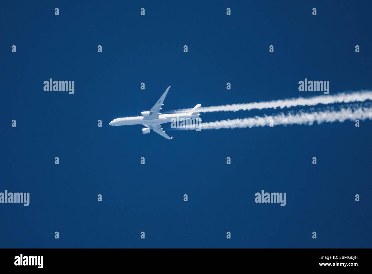 Sharp telephoto close-up of jet plane aircraft with contrails cruising ...