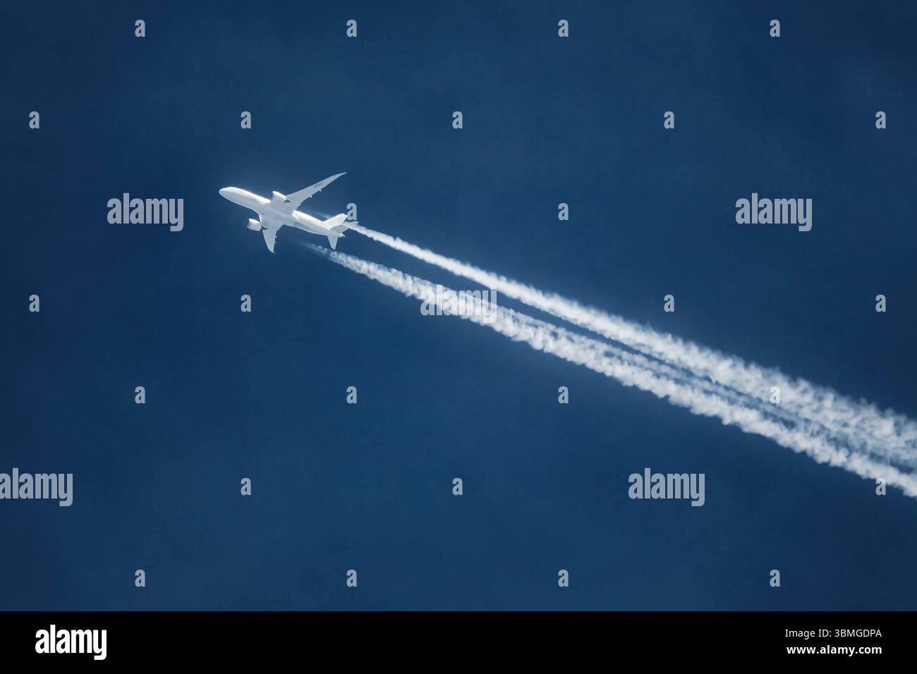 Sharp telephoto close-up of jet plane aircraft with contrails cruising ...