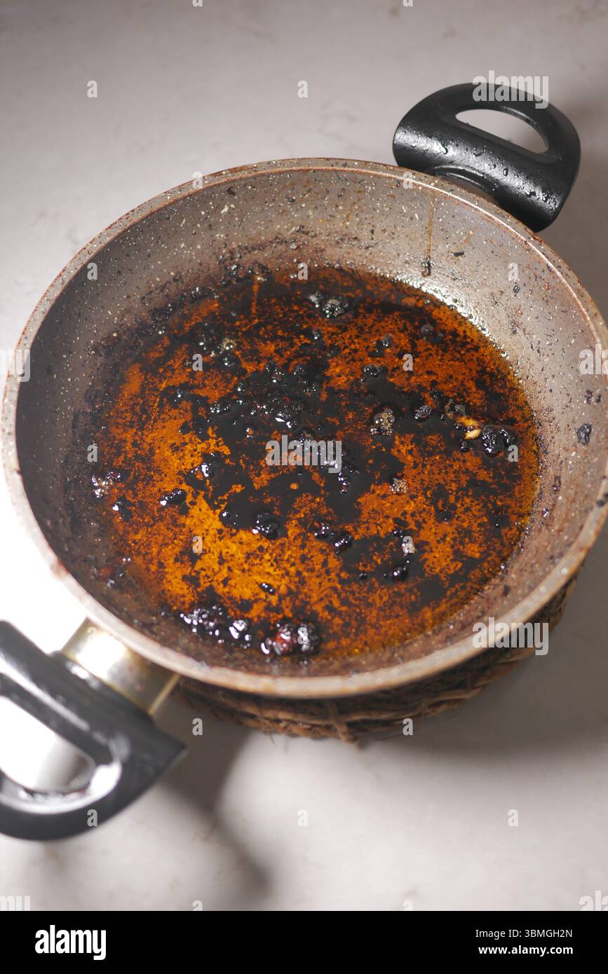 Burnt oil in cooking pot on a kitchen counter Stock Photo - Alamy