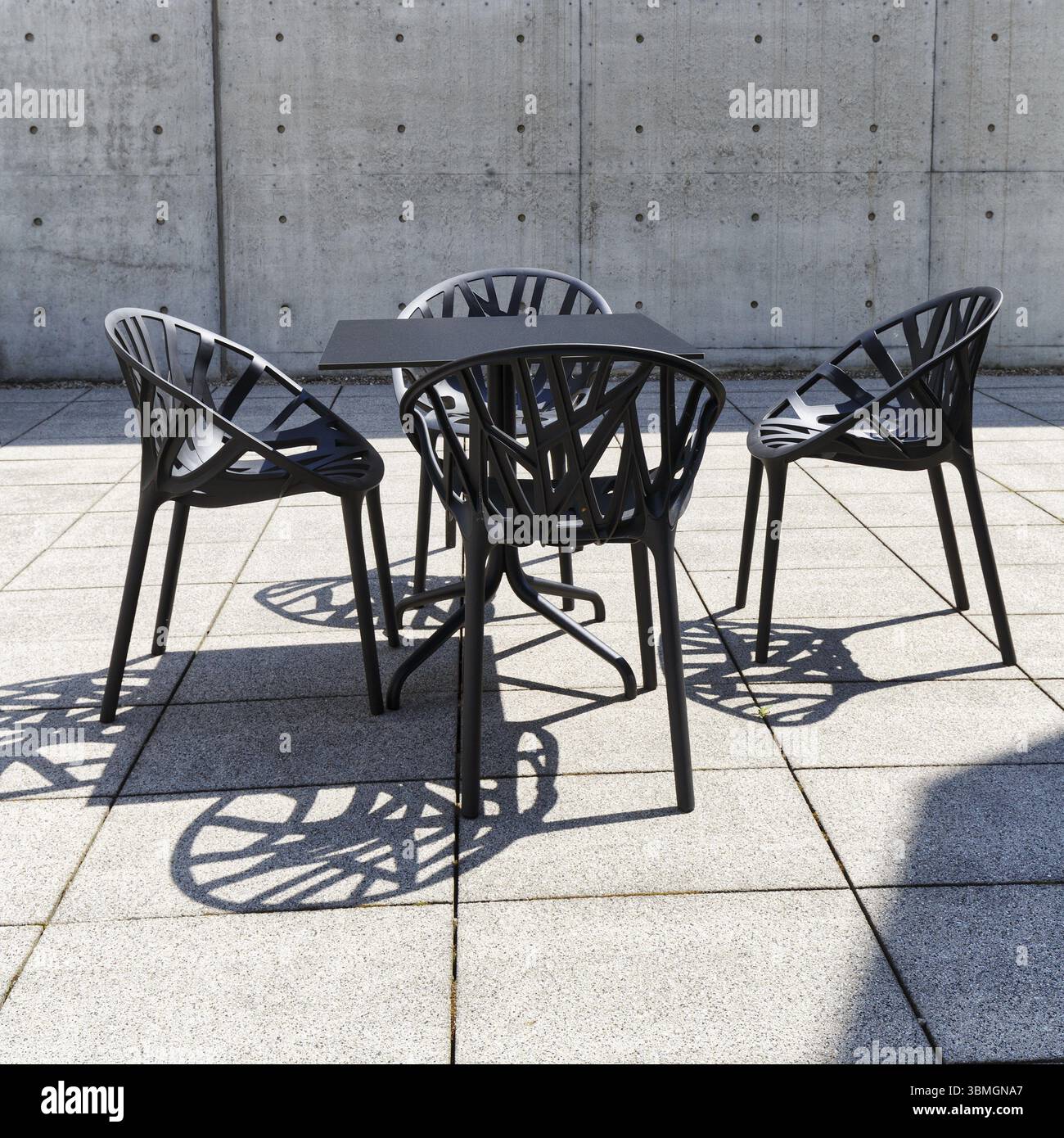 Seating area in the inner courtyard, black table and four plastic ...