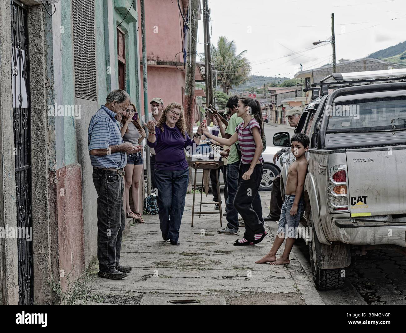 Two women dancing to street musicians, one beckoning for the ...