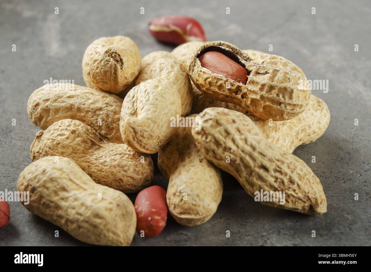 Ripe organic Peanuts in shell on stone table. Healthy eating concept ...