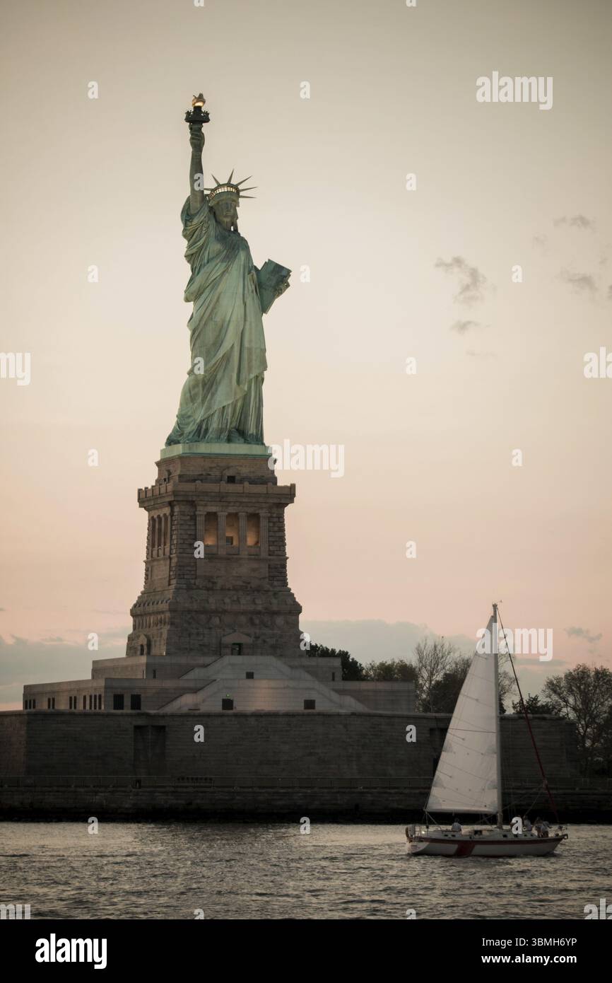 Statue of Liberty, sunset, sailing ship, illuminated Stock Photo - Alamy