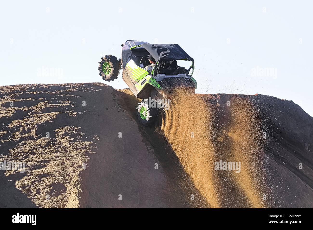 The wheels of a side-by-side spray gravel going over a hill Stock Photo ...