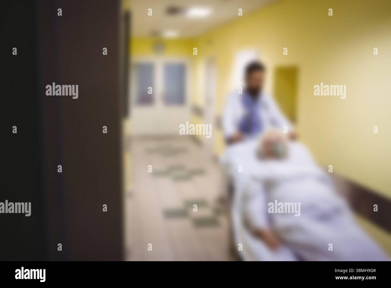 Doctor pushing patient in hospital bed through corridor Stock Photo - Alamy