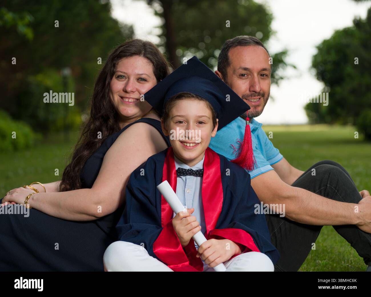 Primary school graduation A boy in his graduation outfit sits on the ...