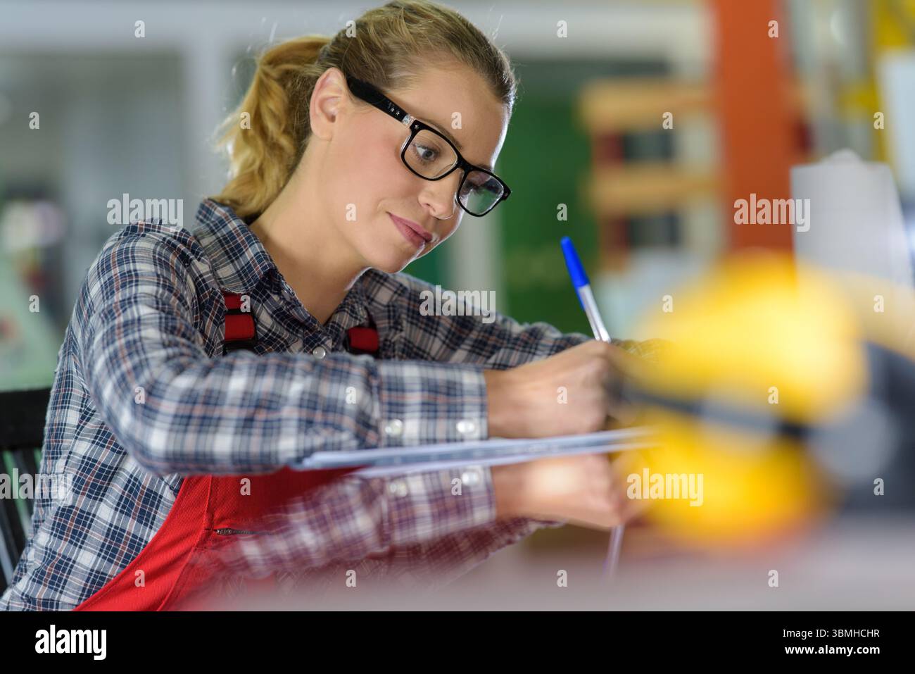 charismatic technician taking notes in the workshop Stock Photo - Alamy