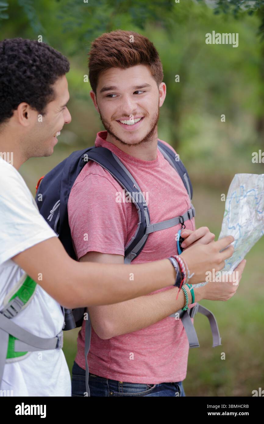 two man hikers looking at map Stock Photo - Alamy