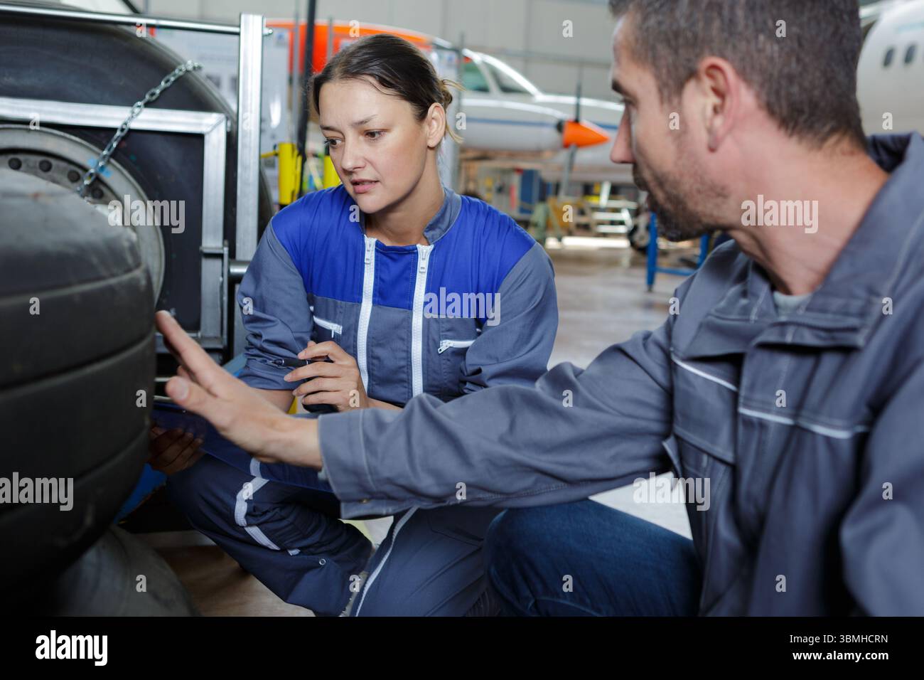 mechanics checking tread on tyre Stock Photo - Alamy