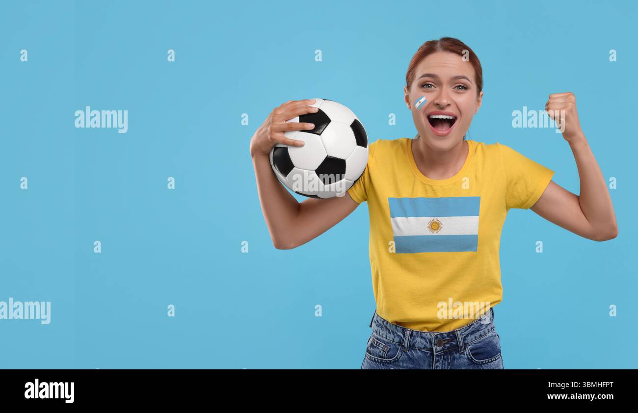 Excited fan with flags of Argentina on her cheek and t-shirt holding ...