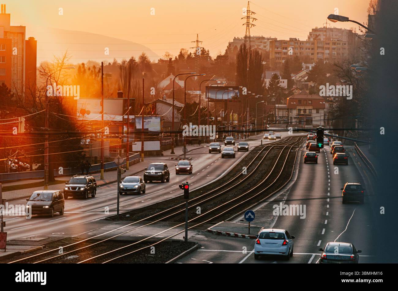 High-contrast photo of urban traffic under sunset light, depicting ...