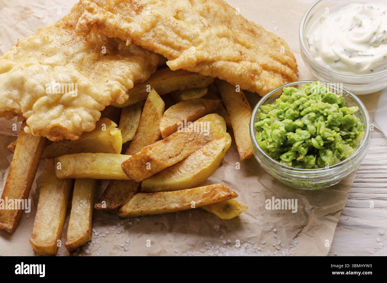 Traditional British street food fish and chips with mushy peas and ...