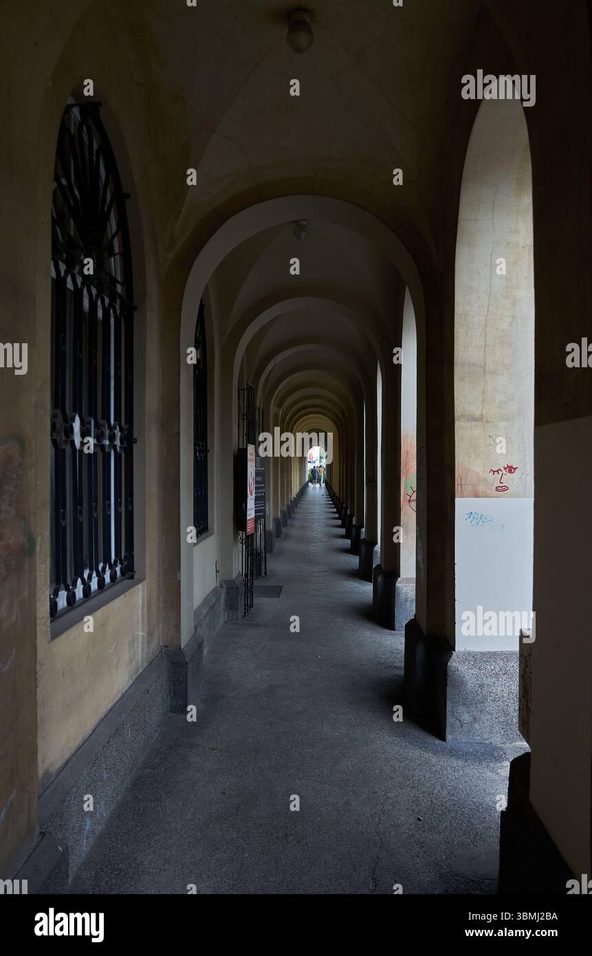 Long hallway with arched windows and a red sign. The hallway is empty ...