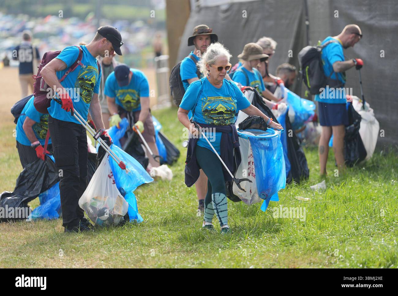 Litter pickers work to clear rubbish at the Glastonbury Festival, at ...
