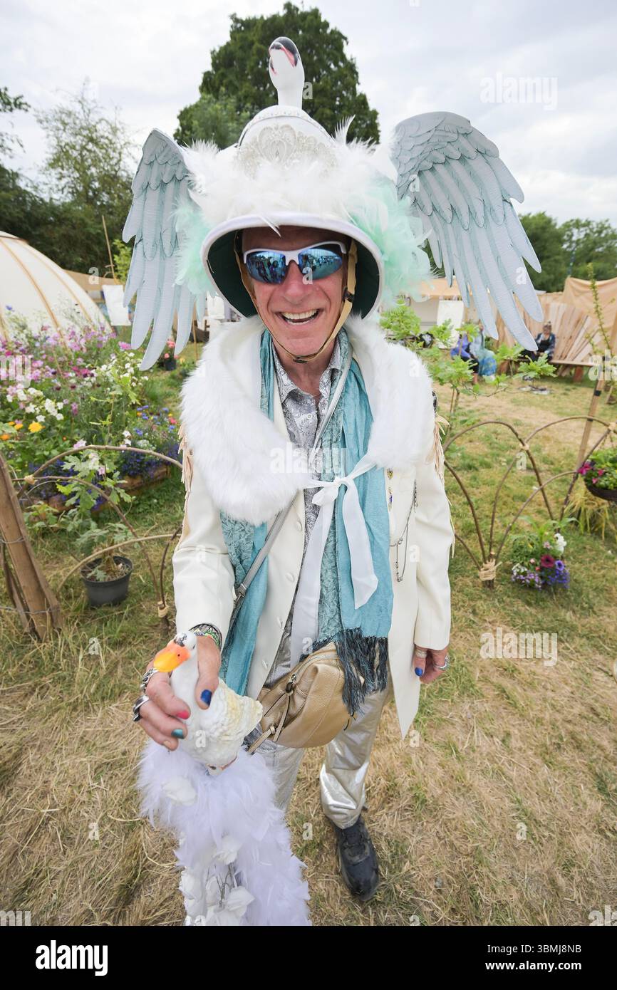 Glastonbury, UK. 25th June, 2025. A man with a swan helmet in the green ...