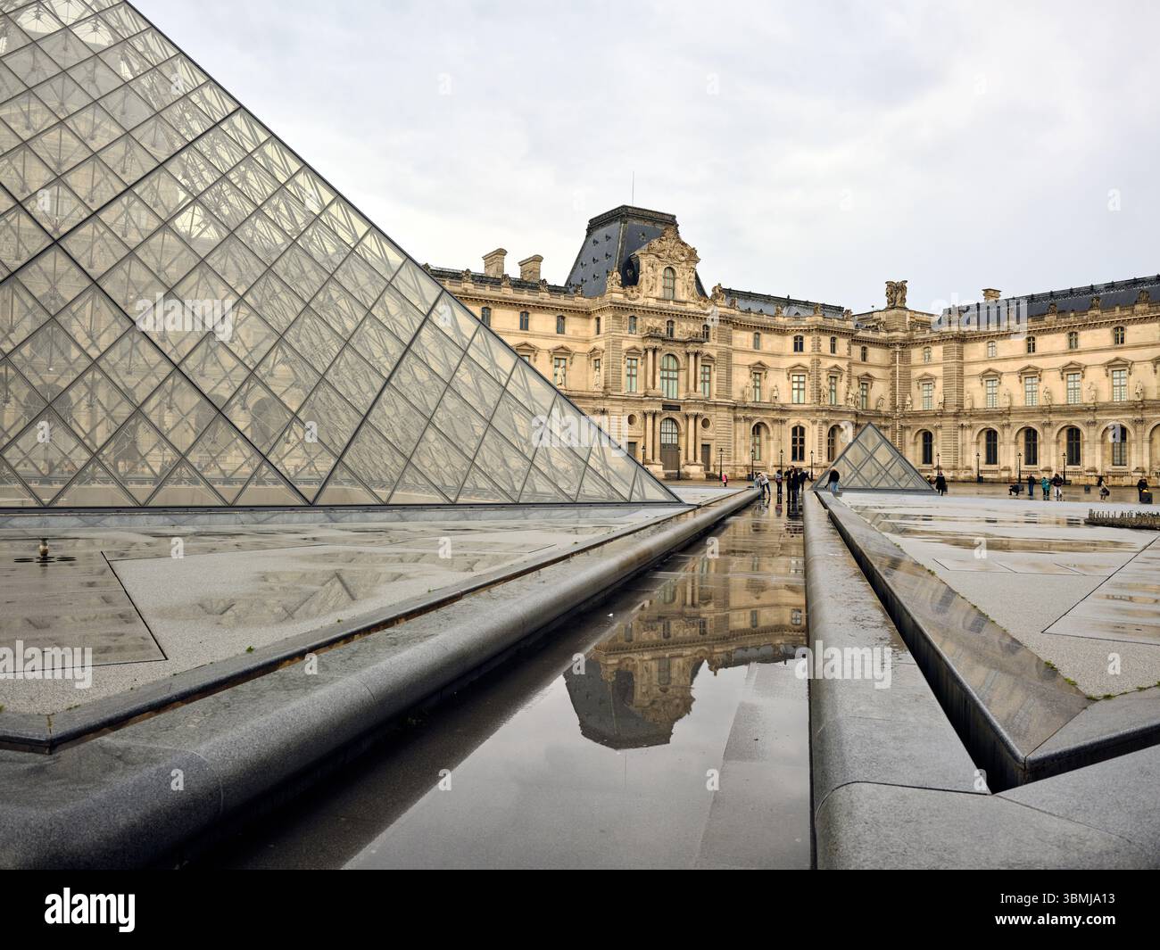 Louvre museum reflecting in water on rainy day in paris Stock Photo - Alamy