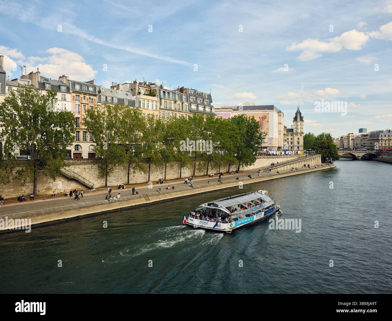 Tourist boat cruising along the seine with people relaxing Stock Photo ...
