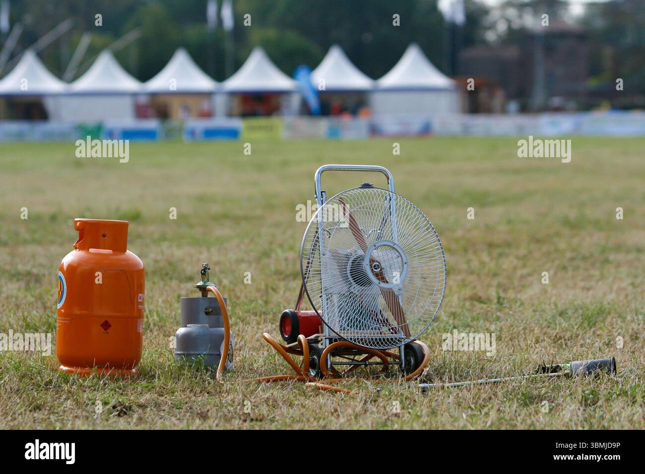 Portable fan and gas cylinders are inflating a hot air balloon at a ...