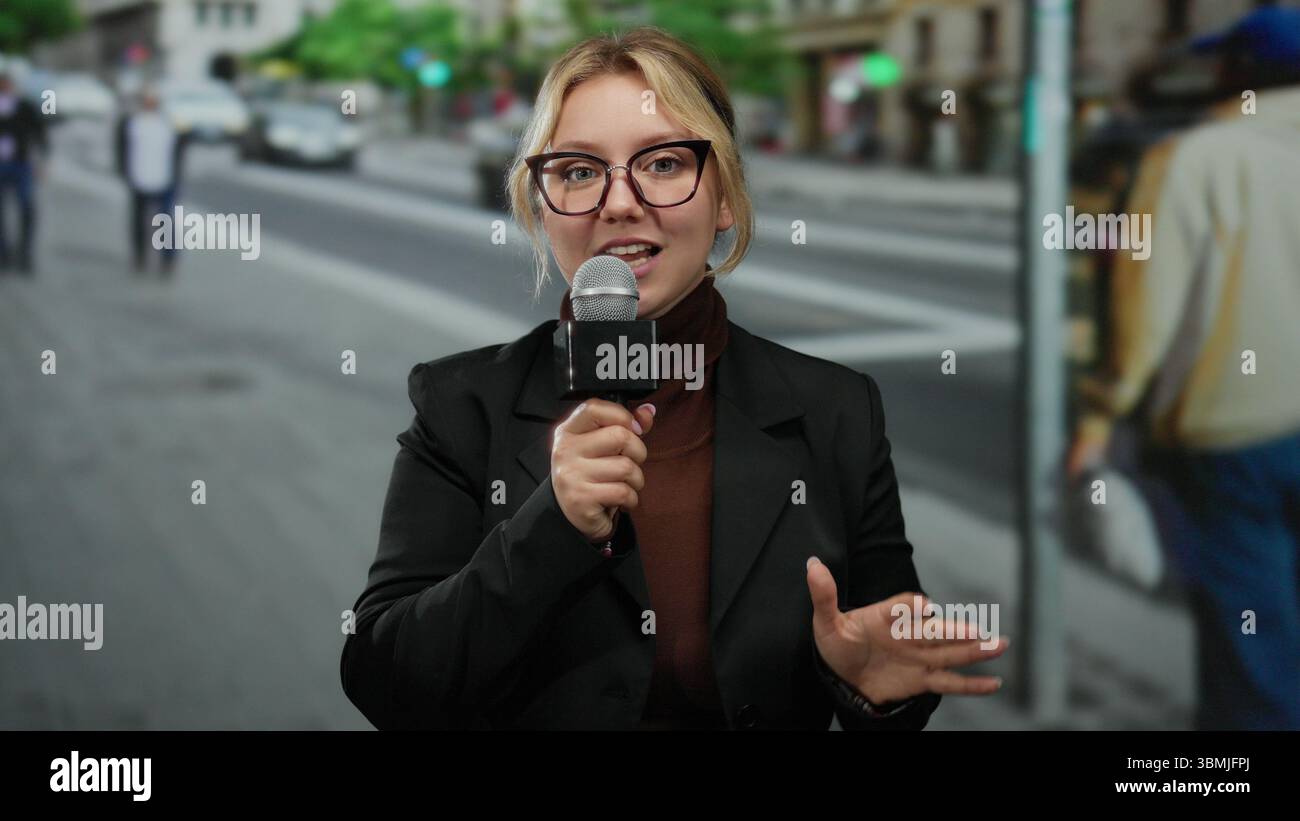 Young woman reporter holding microphone on city street outdoors with ...