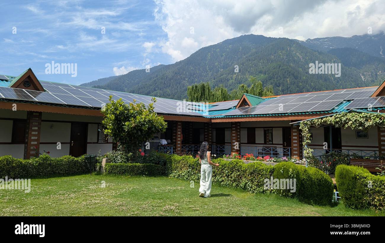 Girl soaking in the view from the house with solar panel roofs on the ...