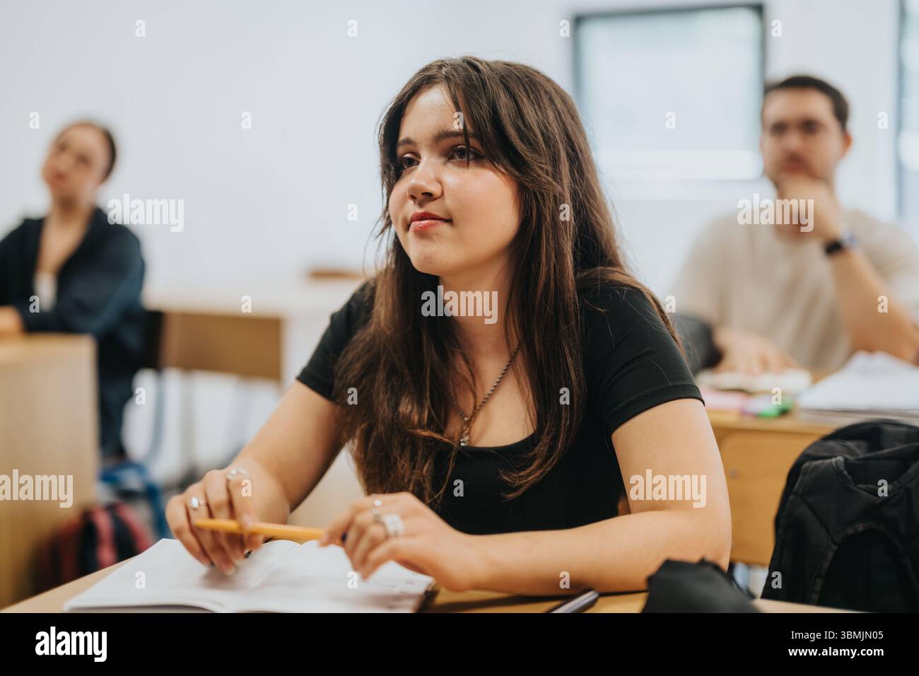 Engaged high school students attentively listening in classroom setting Stock Photo - Alamy