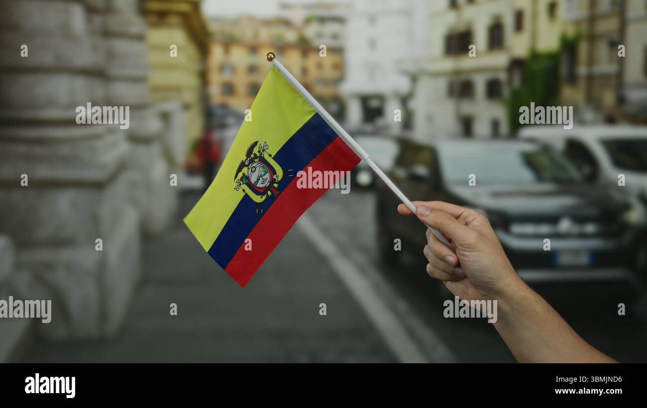 Male hand holding ecuadorian flag on busy city street offers vibrant ...