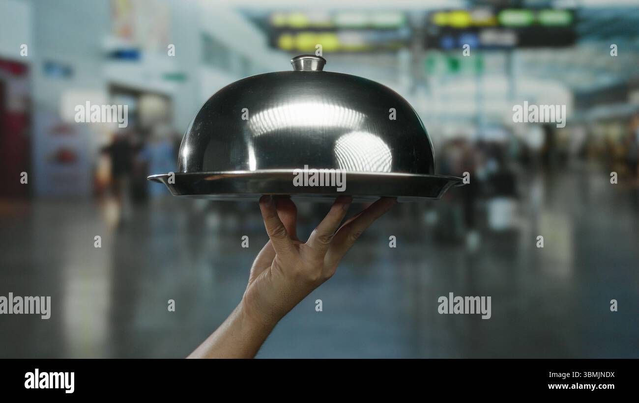 Hand of man holding a cloche at an airport terminal showcasing ...
