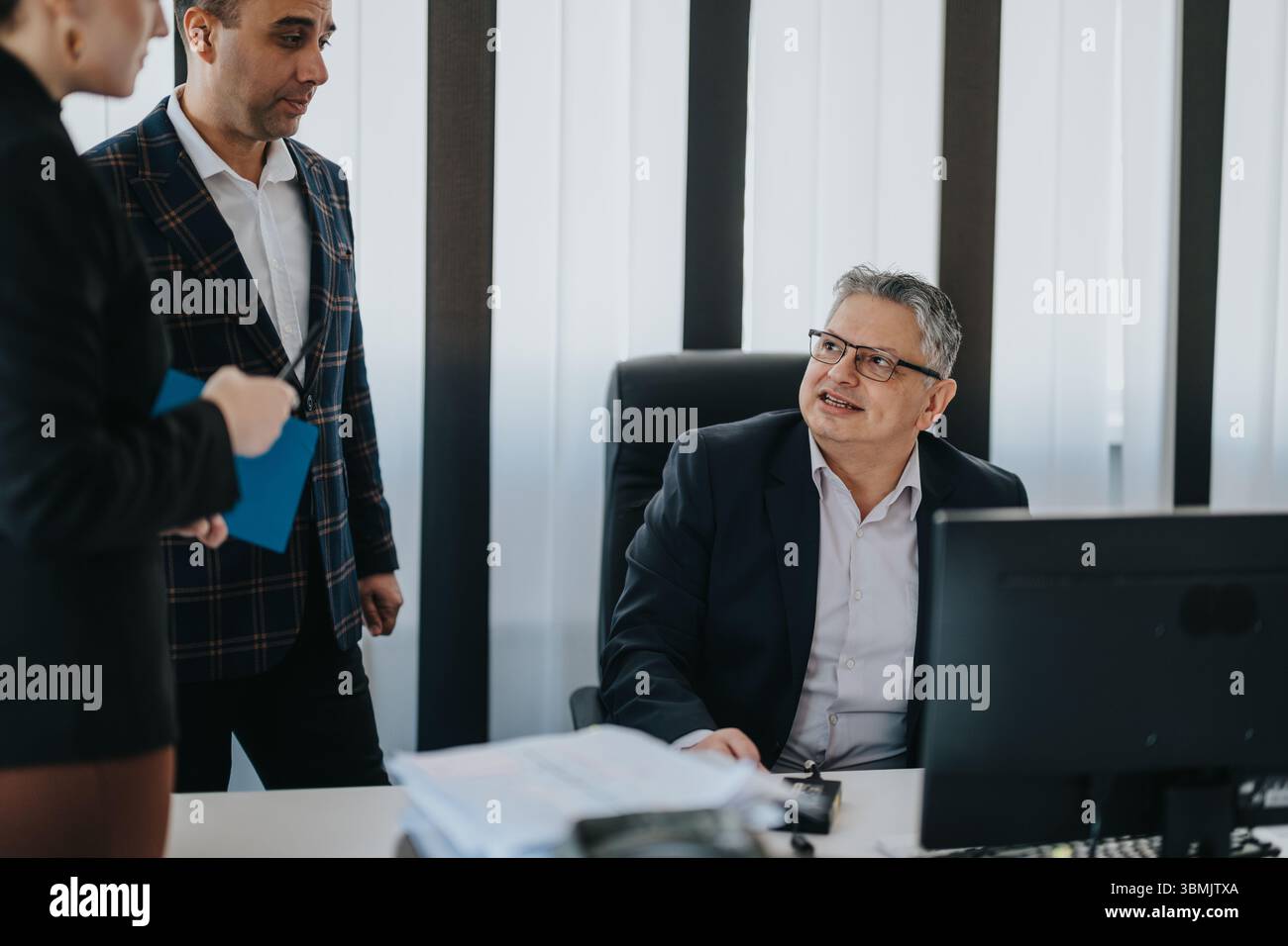 Business team collaborating at office desk with computer and ...