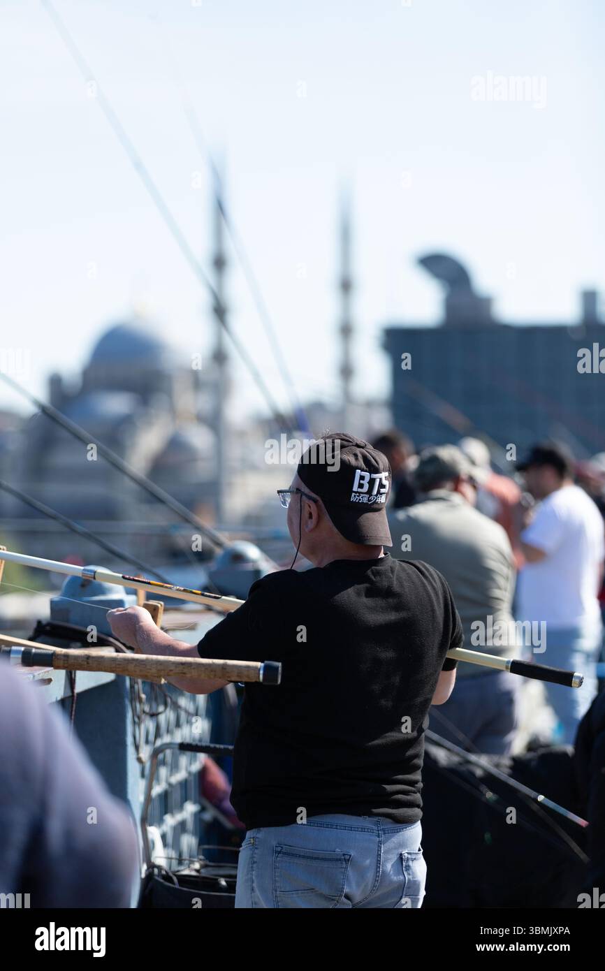 Istanbul, Turkiye - 12 May 2025: People fishing over the Galata Bridge ...