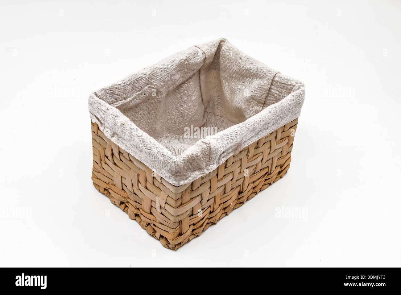 Woven wicker basket with beige linen fabric liner, empty and clean ...