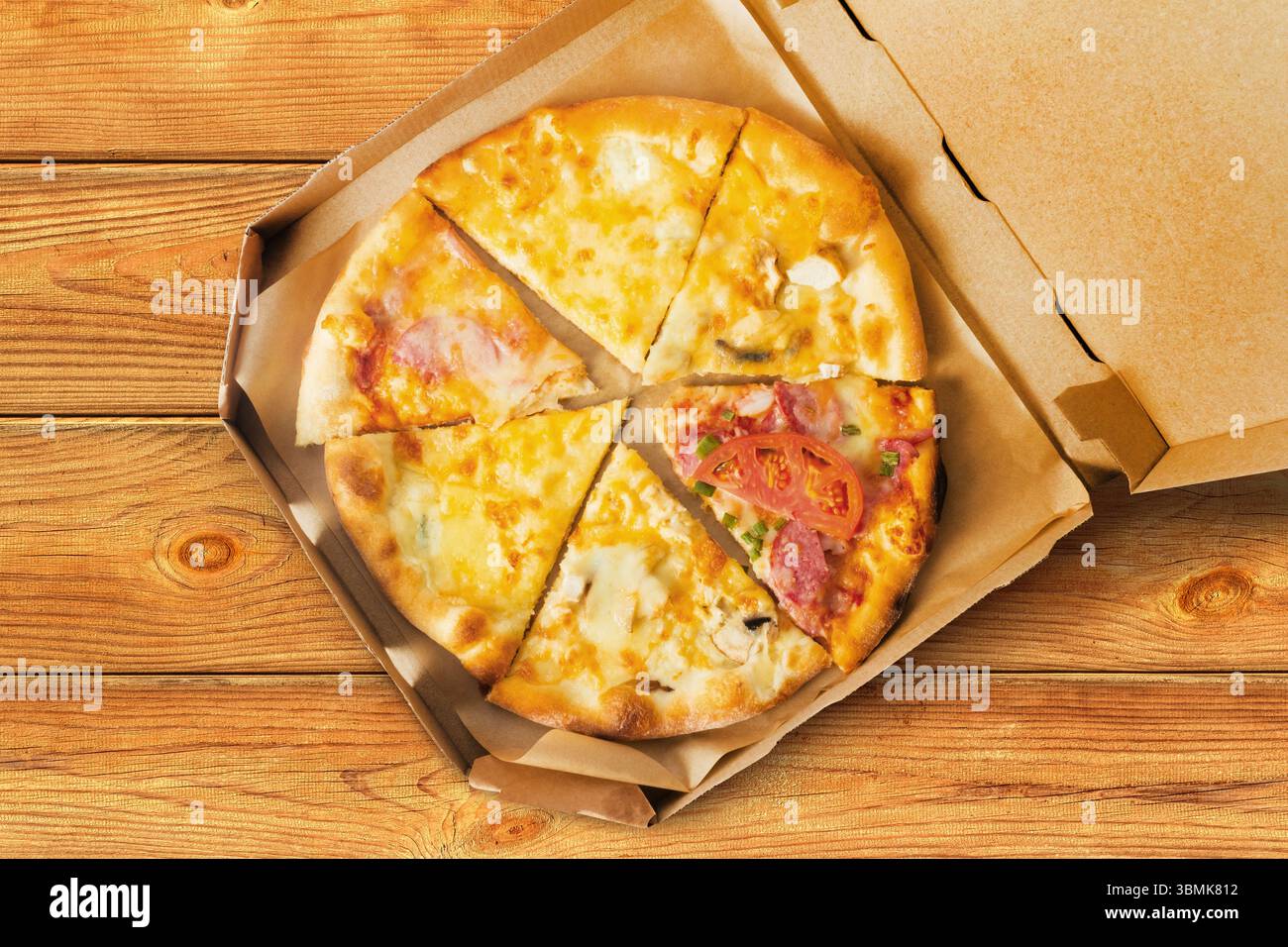Photo of various type pizza slices served in cardboard box on light ...