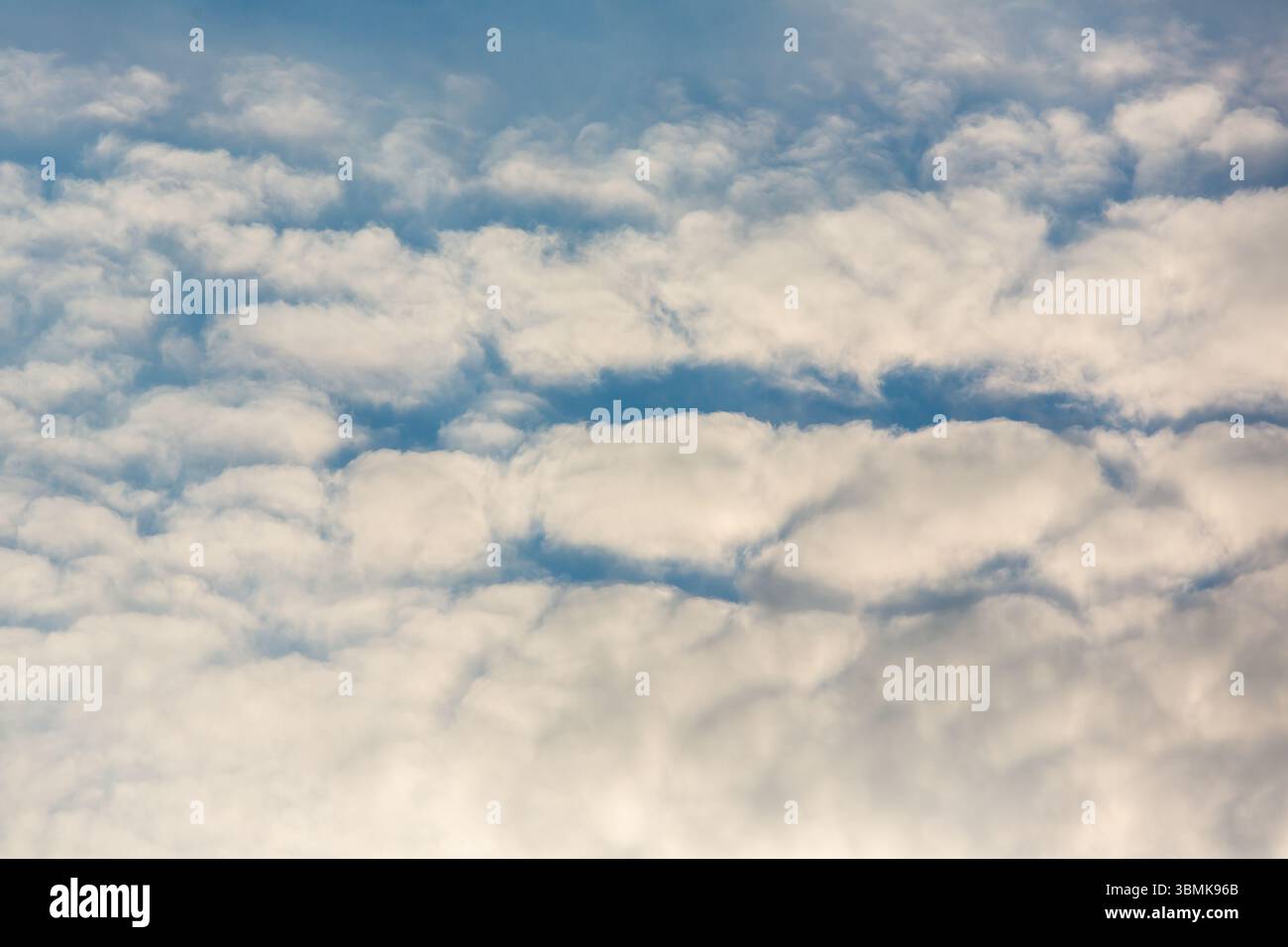 Soft stratocumulus clouds spread across the sky, creating a textured ...