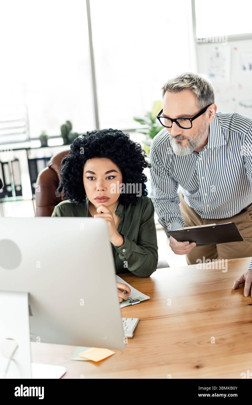 Young professionals collaborating in an office environment with focus ...